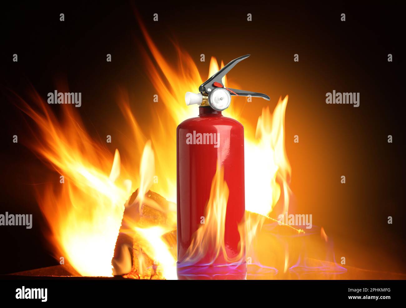 Fire extinguisher surrounded by flame on dark background Stock Photo ...