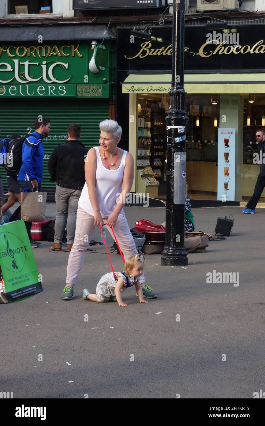 Toddler wearing a child harness for safety in busy Grafton Street ...