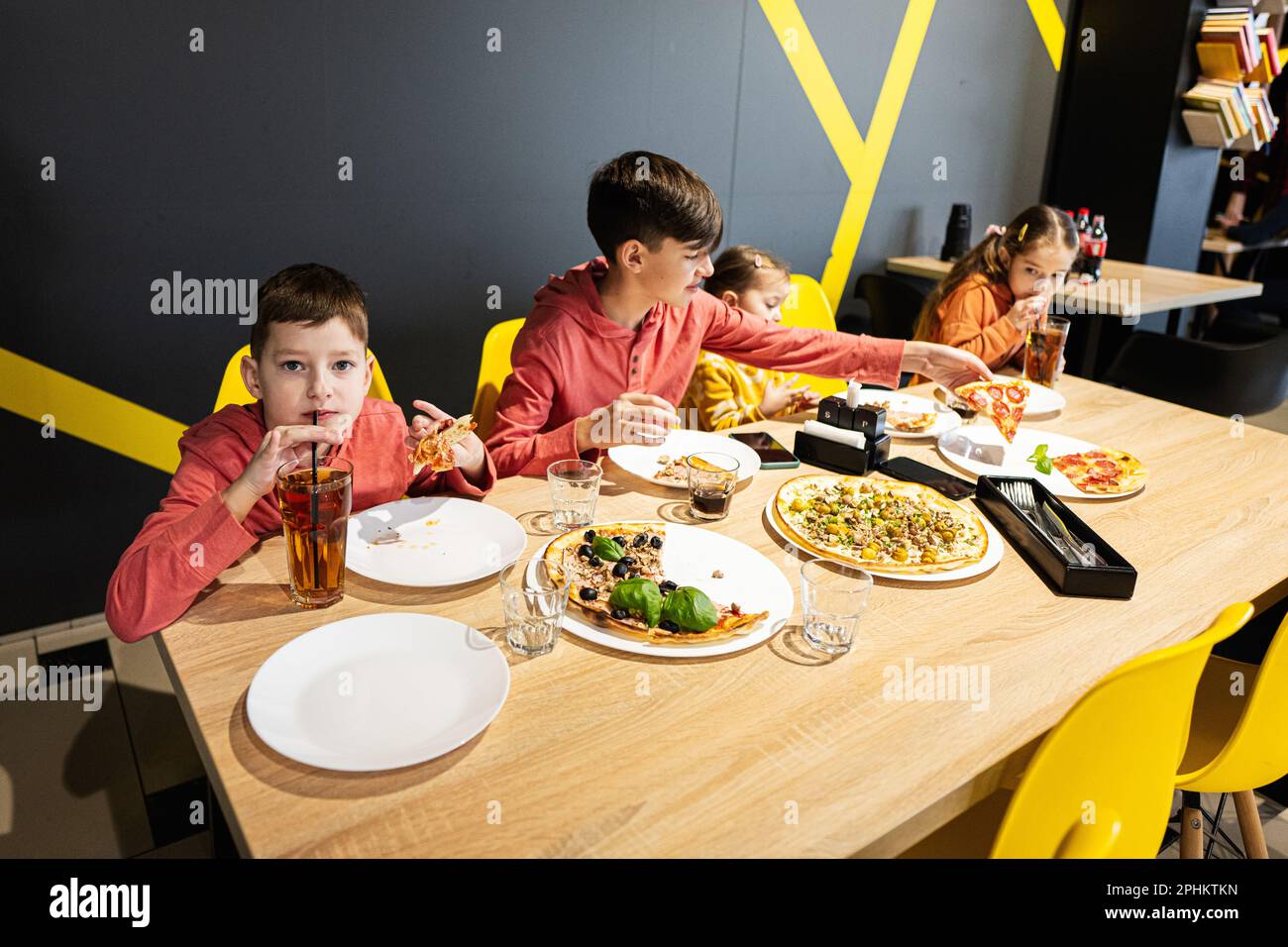 Four kids eating italian pizza in pizzeria. Children eat at cafe. Boy ...
