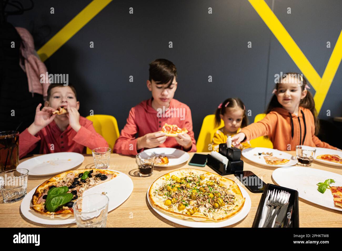Four kids eating italian pizza in pizzeria. Children eat at cafe Stock ...
