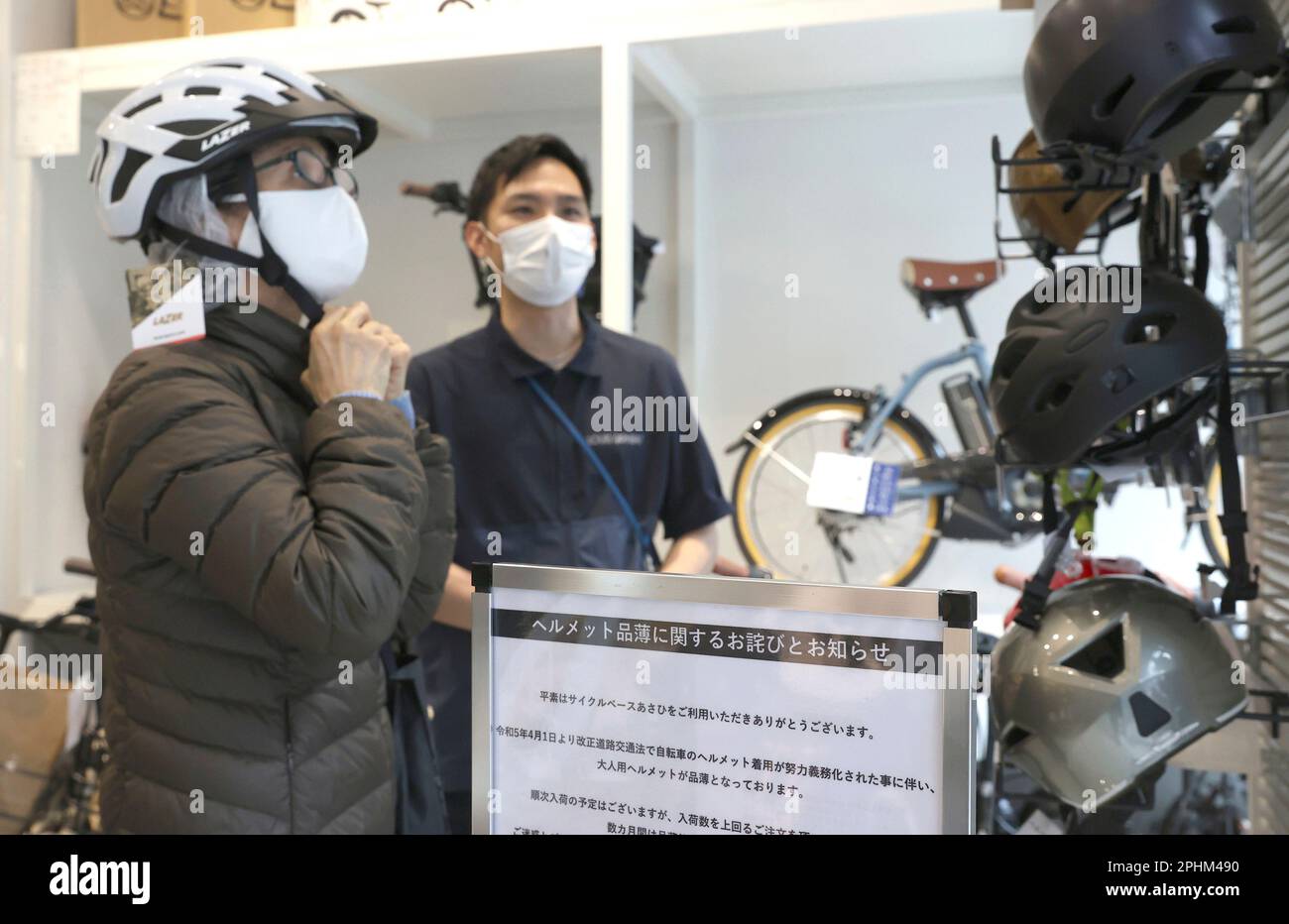 An employee of Cycle Base Asahi shows bicycle helmets in Shibuya Ward ...