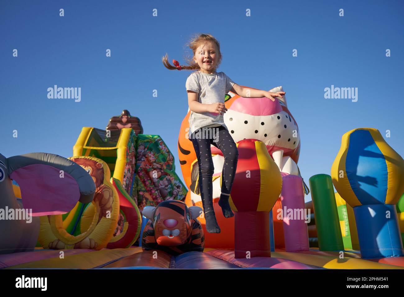 Happy baby girl jumping on an inflatable trampoline Stock Photo - Alamy