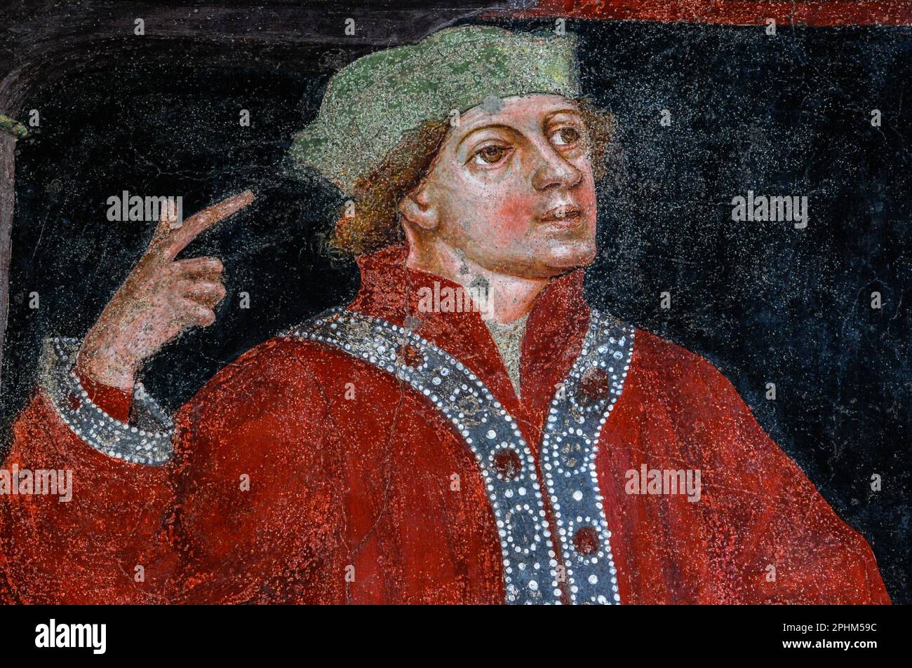 Mind your head … a young prince or nobleman in a fine red robe points ...
