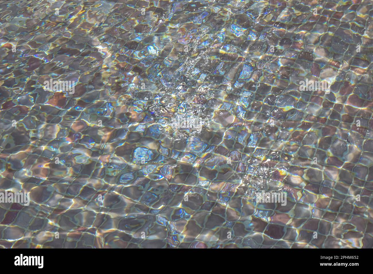 Unusual glare on water in pool. Water surface with bizarre small waves ...
