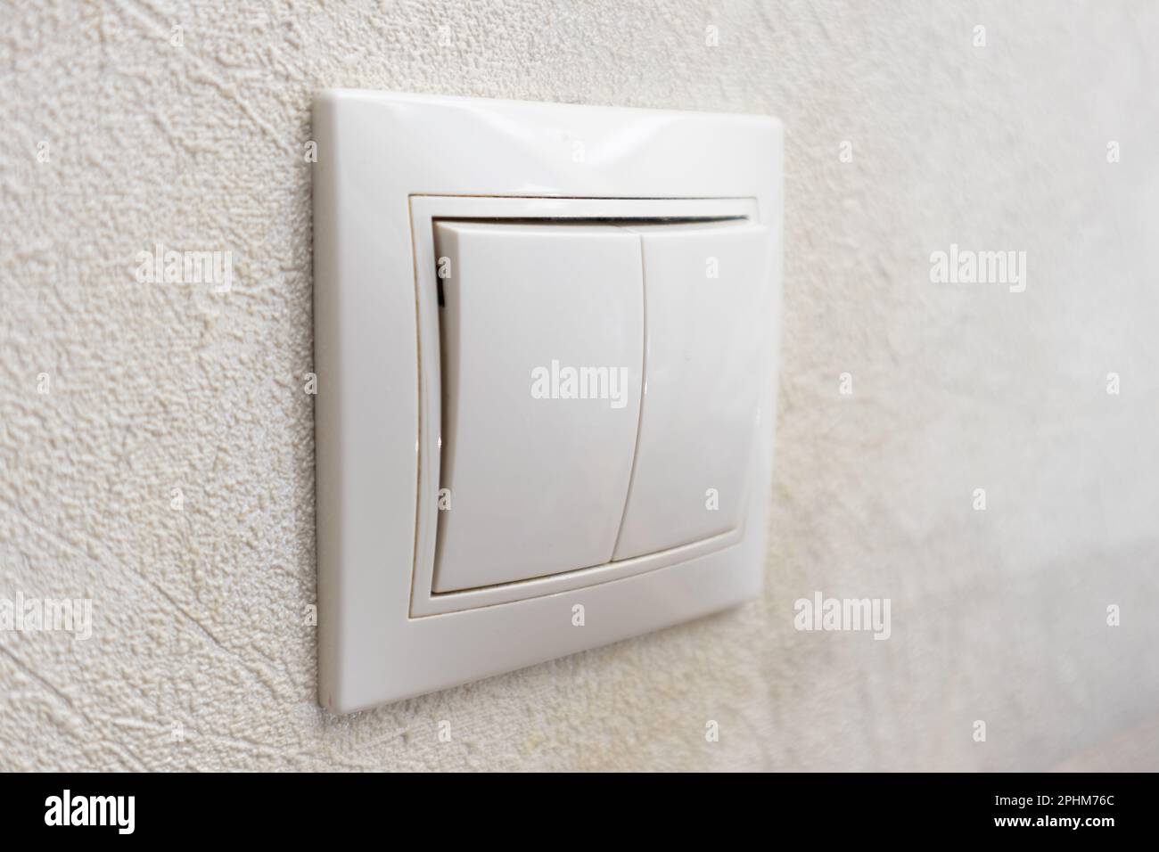 Electric light switch on the background of light textured wallpaper ...