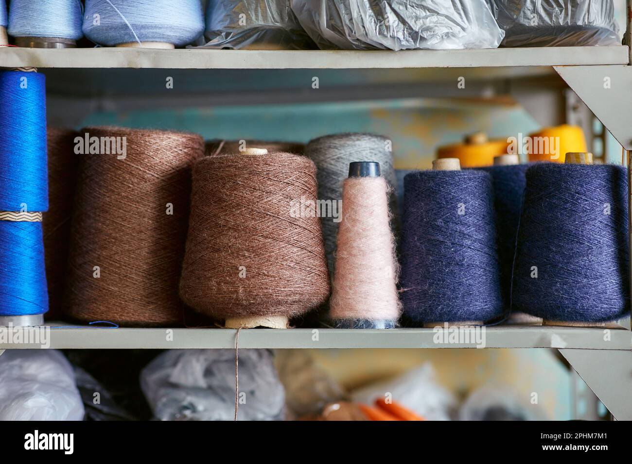 Bobbins with knitted threads stand in a row on the rack Stock Photo - Alamy