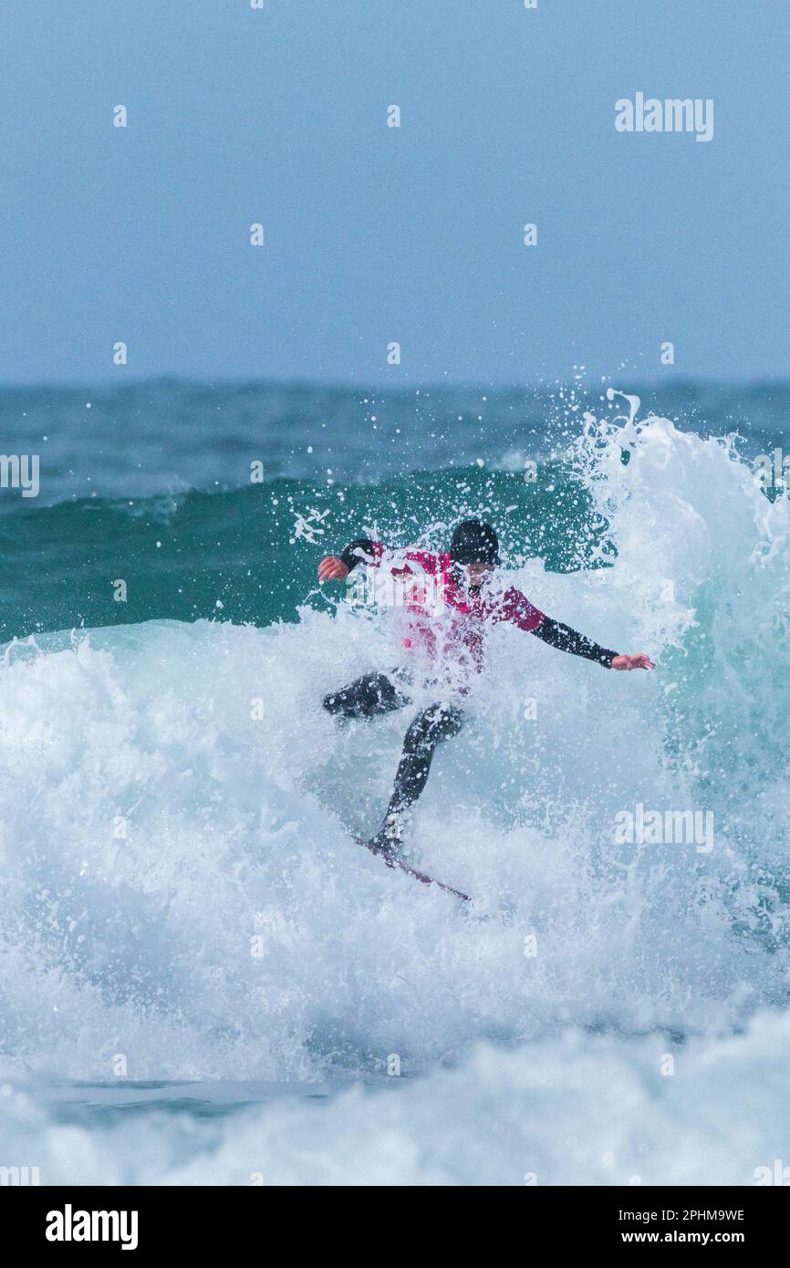 A young male surfer riding a wave during the Rip Curl Grom Search ...