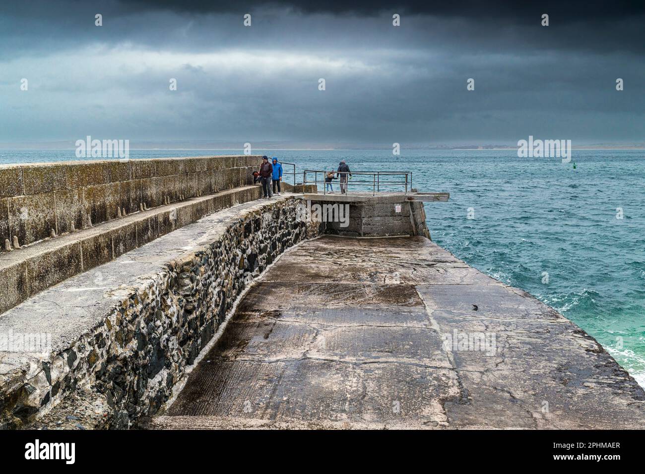 UK weather. Visitors walking on The Wharf on a rainy chilly miserable ...