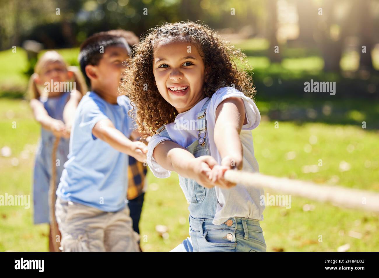 Funny, games and children playing tug of war together outdoor in a park ...