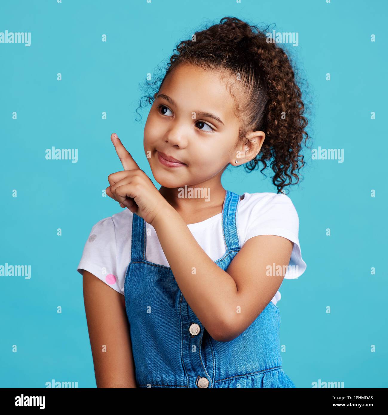 Girl child, thinking and point in studio with idea, looking and young ...