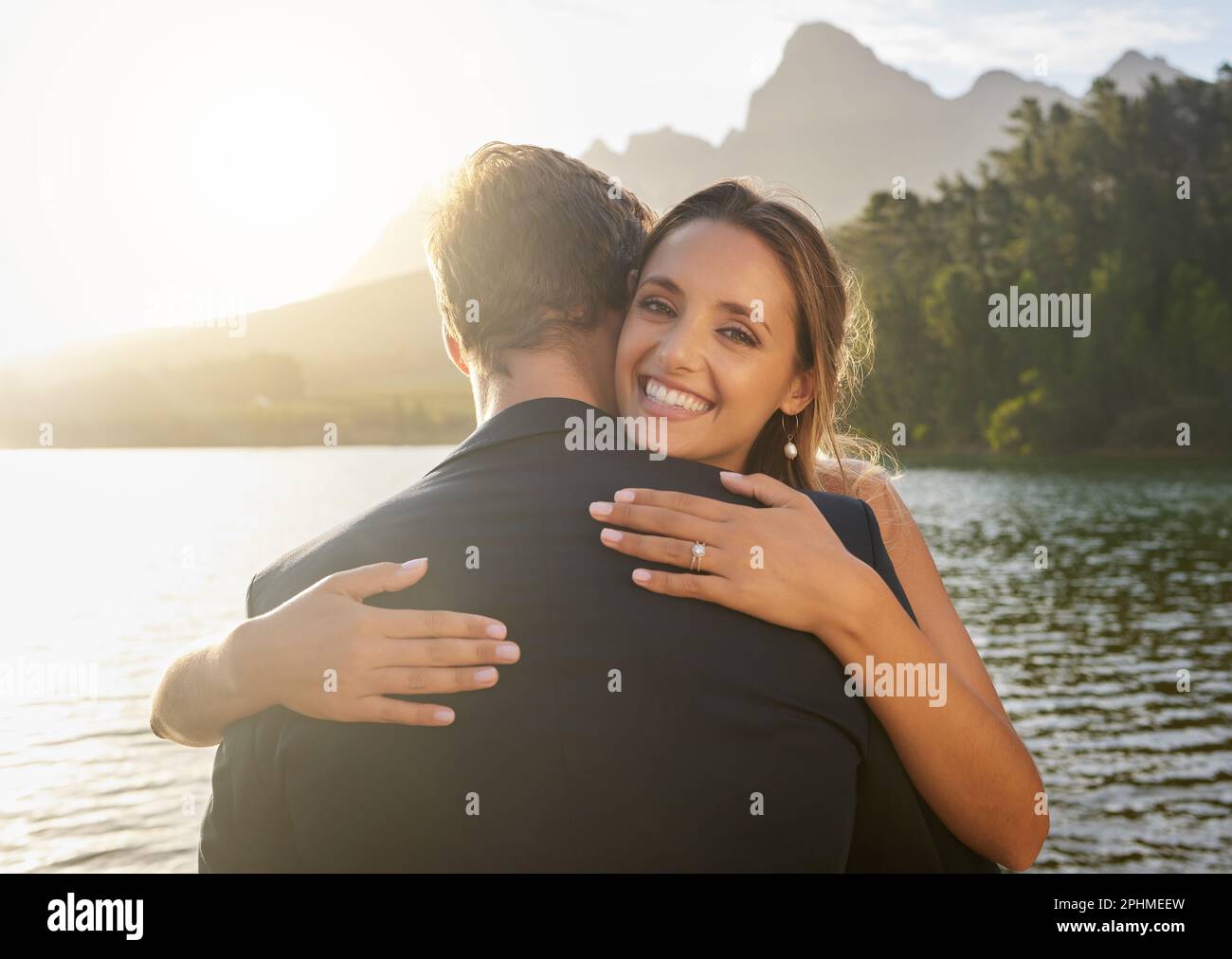 Wedding, lake and portrait of happy couple hugging in nature and water ...