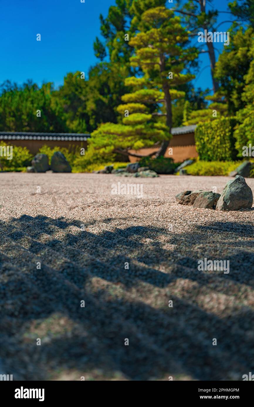 A tranquil Japanese garden surrounded by large rock formations and ...