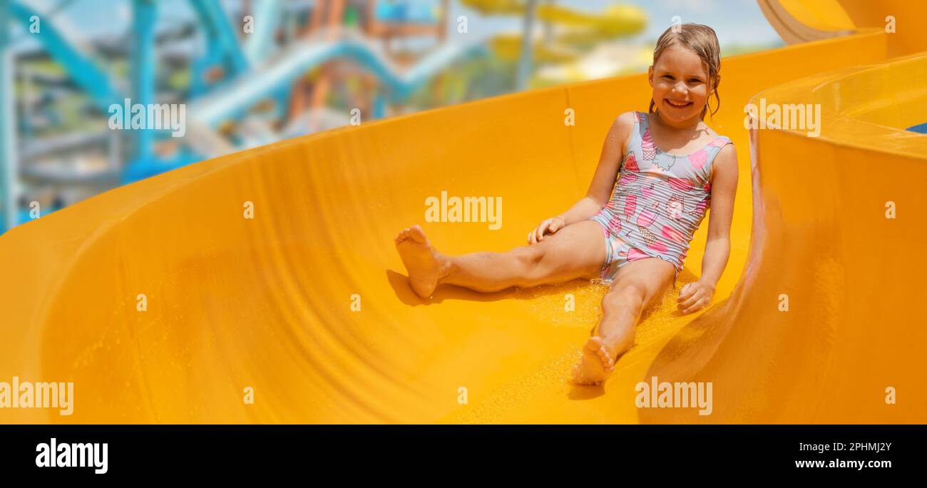 happy child on slide at outdoor water park. banner with copy space ...