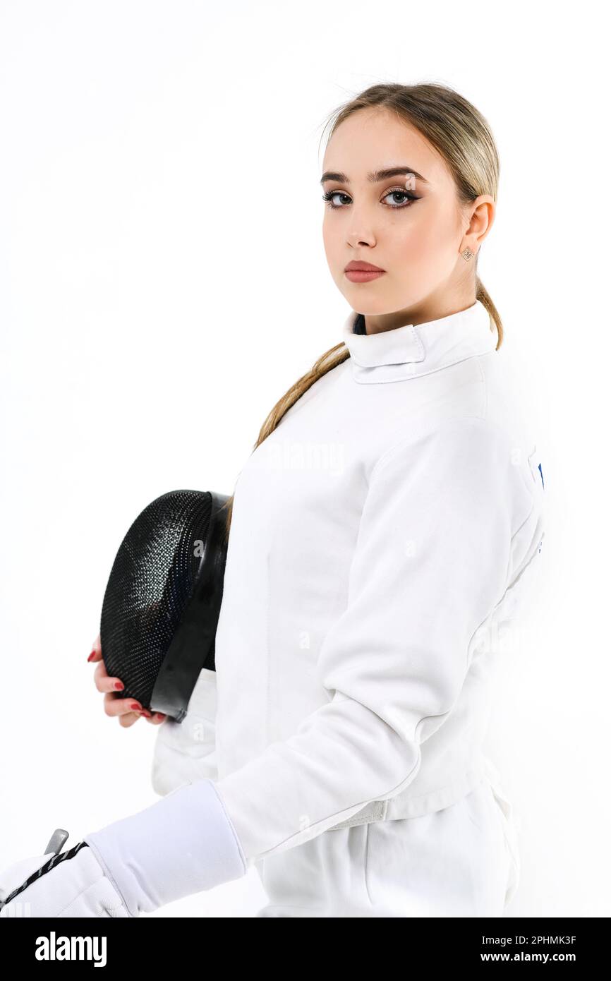 Girl fencer with a sword on a white background. Portrait of a girl in a fencing costume with a ...