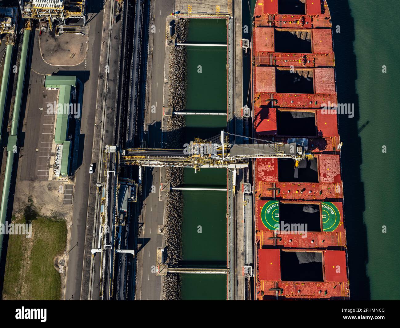 Two traditional cargo vessels are docked in a tranquil body of water ...