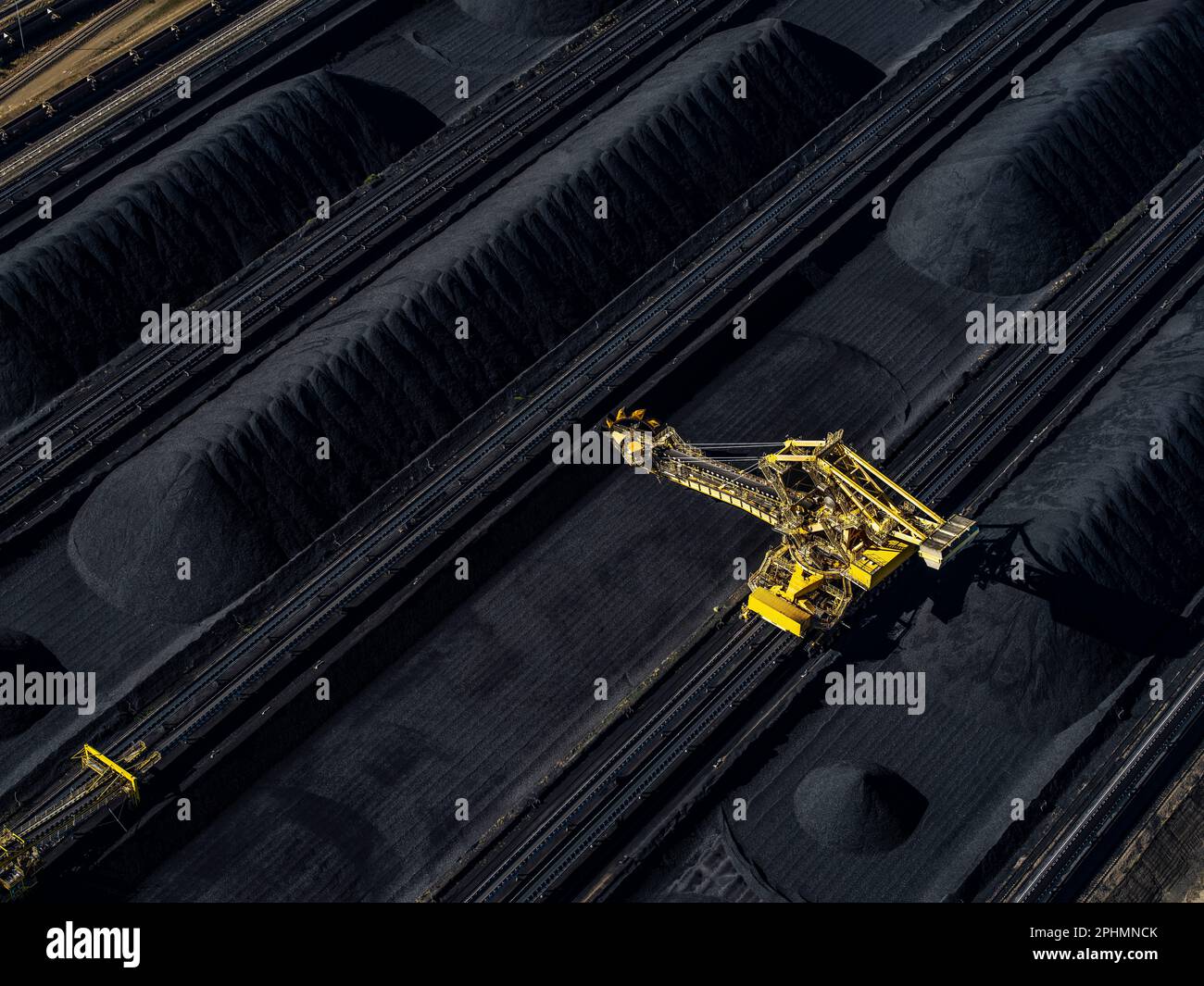 A large industrial machine, positioned on a set of railway tracks, is ...