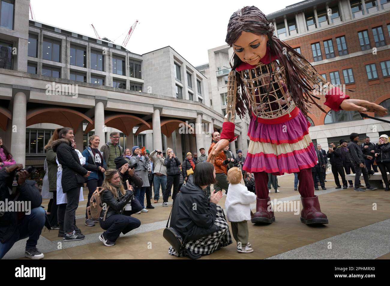 People watch as the puppet called Little Amal performs in Paternoster ...