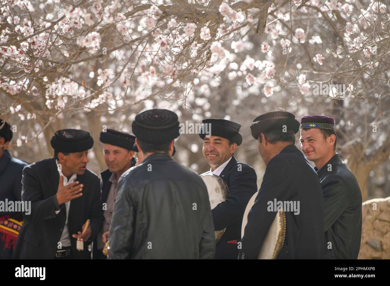 Akto, March 29, 2023 (Xinhua) -- Villagers chat amid apricot trees in ...