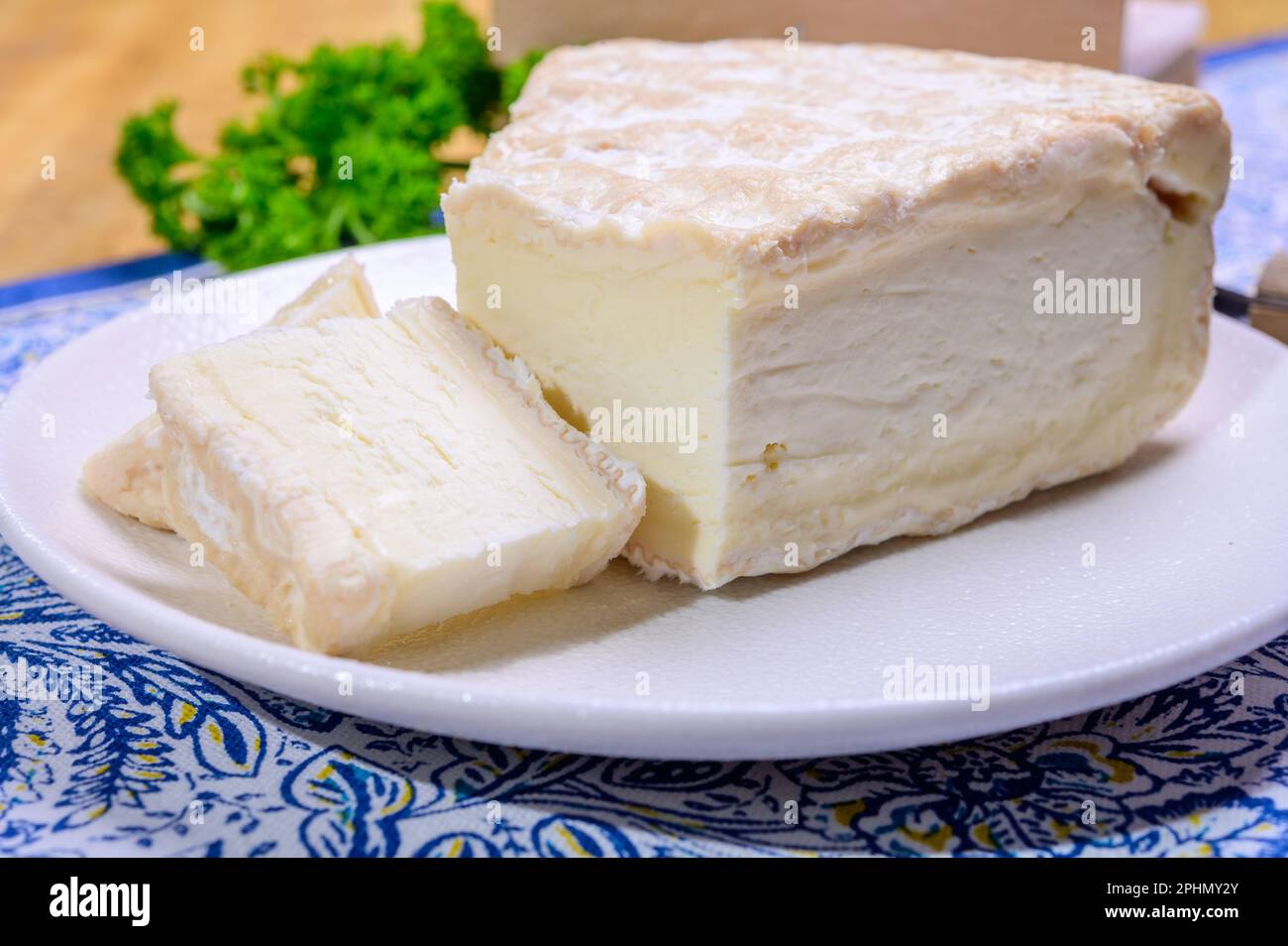 Piece of french soft-ripened white mold cow milk cheese brie produced ...