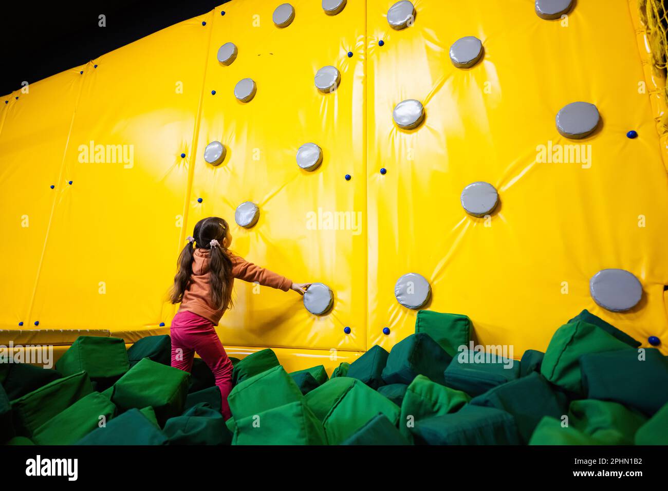 Little girl kid climbing wall at yellow playground park. Child in ...