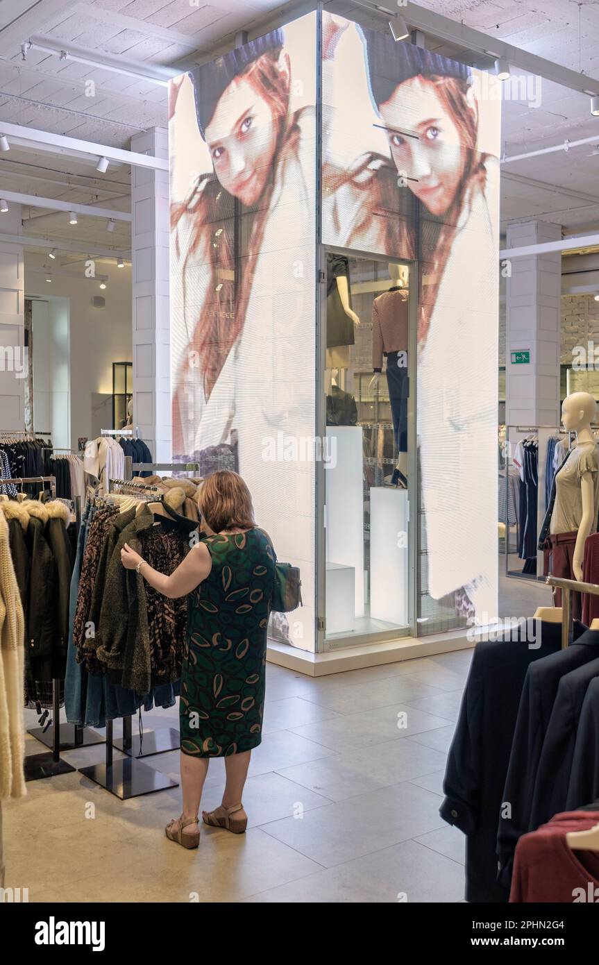 Interior of a clothing store with illuminated advertising in the city ...