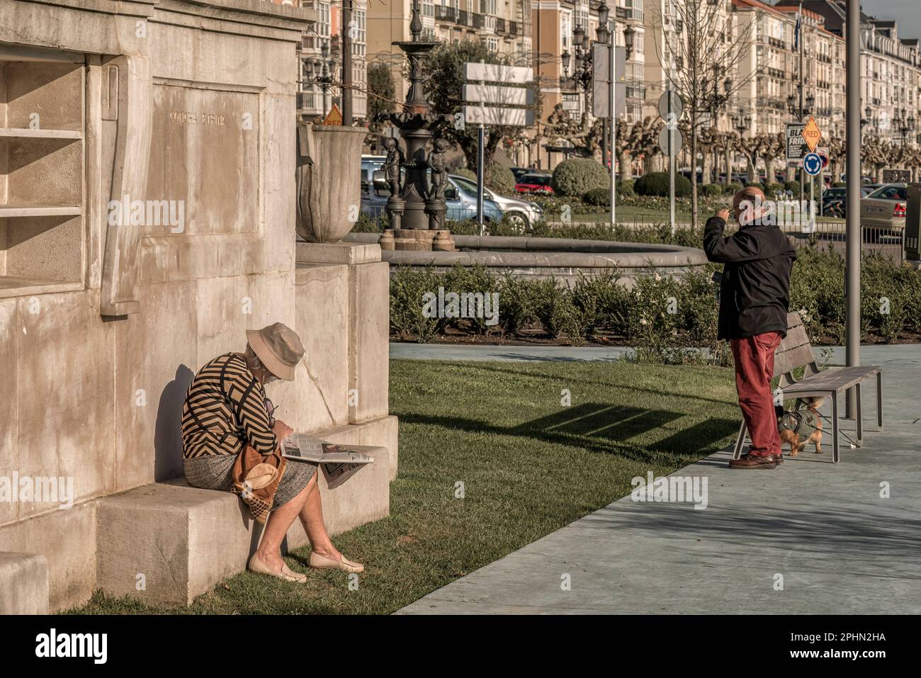 Senior woman reading the newspaper sitting on a bench at the Concha ...