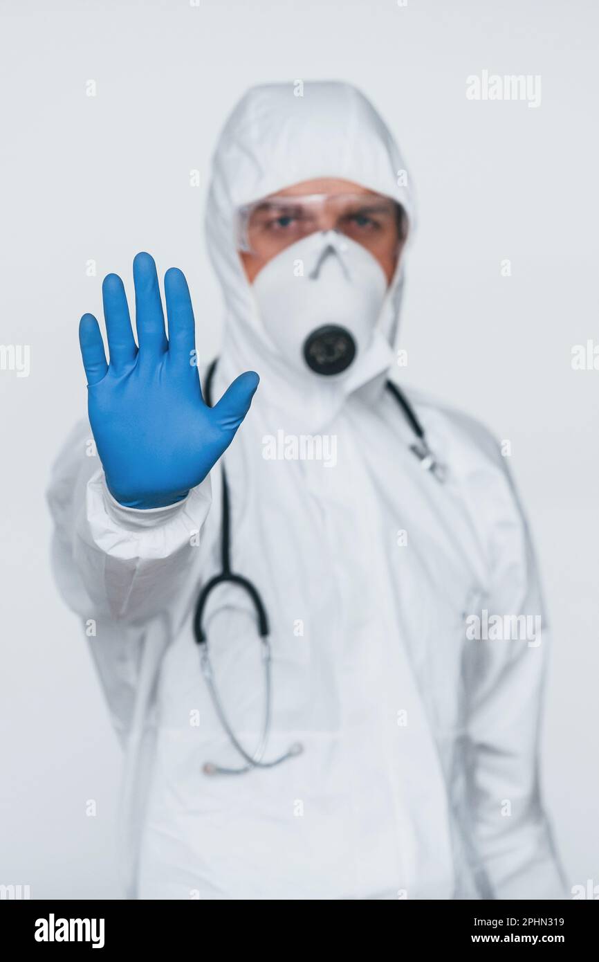 Shows stop gesture by hand. Male doctor scientist in lab coat ...