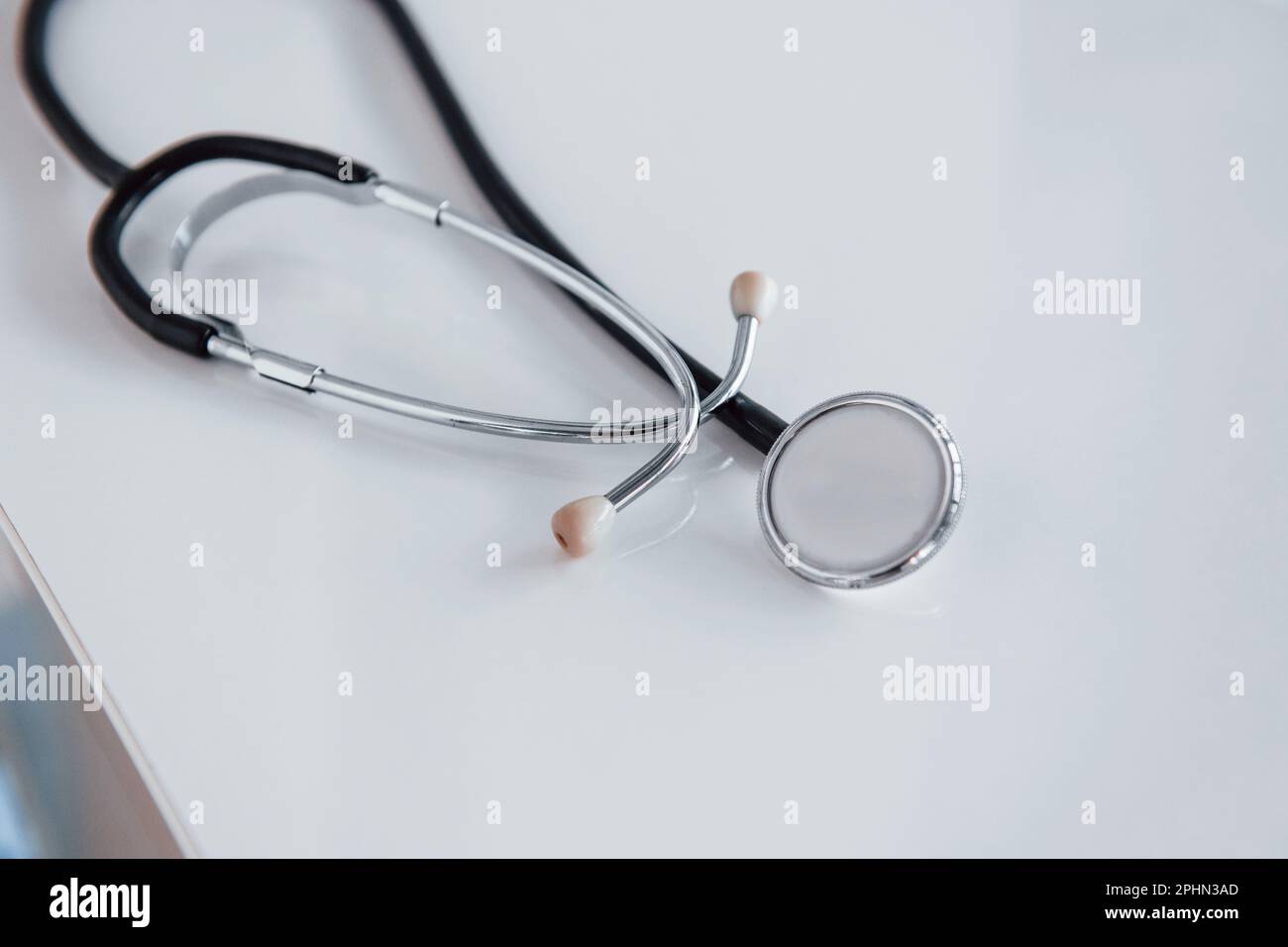 Close up view of medical stethoscope that lying down on white table ...