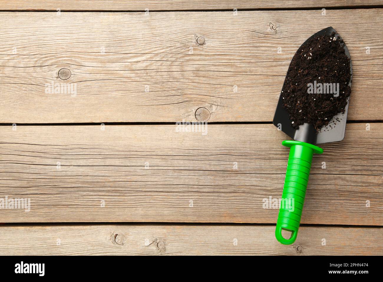 Green garden tools shovel and soil on grey background Stock Photo - Alamy