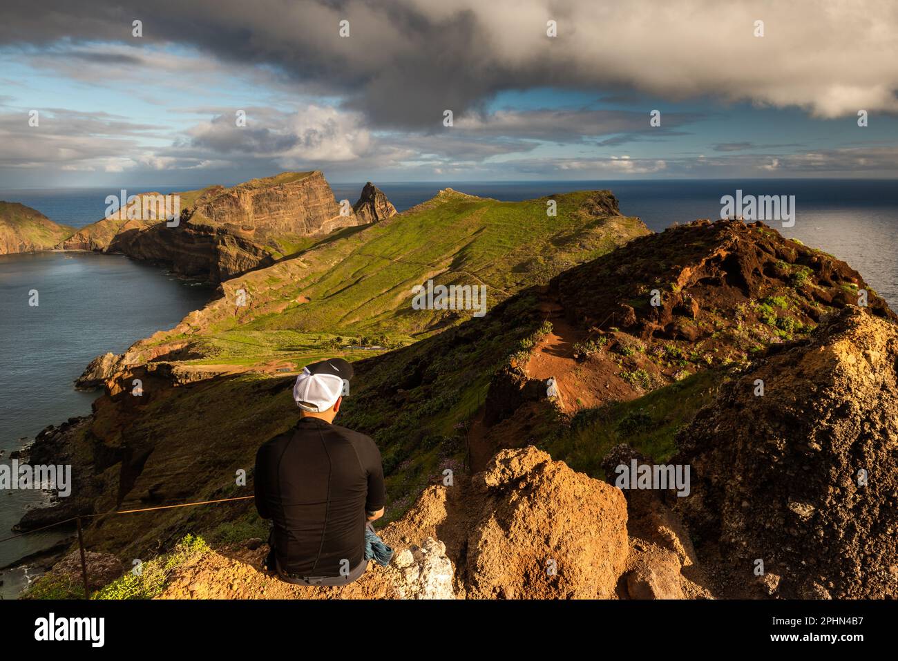 Adventure man sitting on hiking trial at Vereda da Ponta do Sao ...