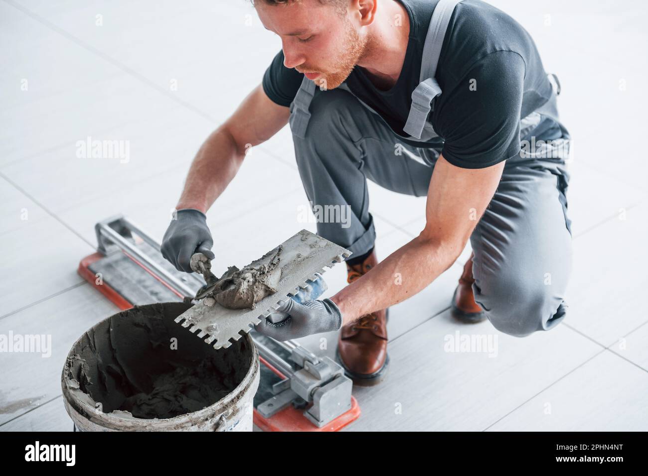 Man in grey uniform works with plate indoors in modern big office at ...