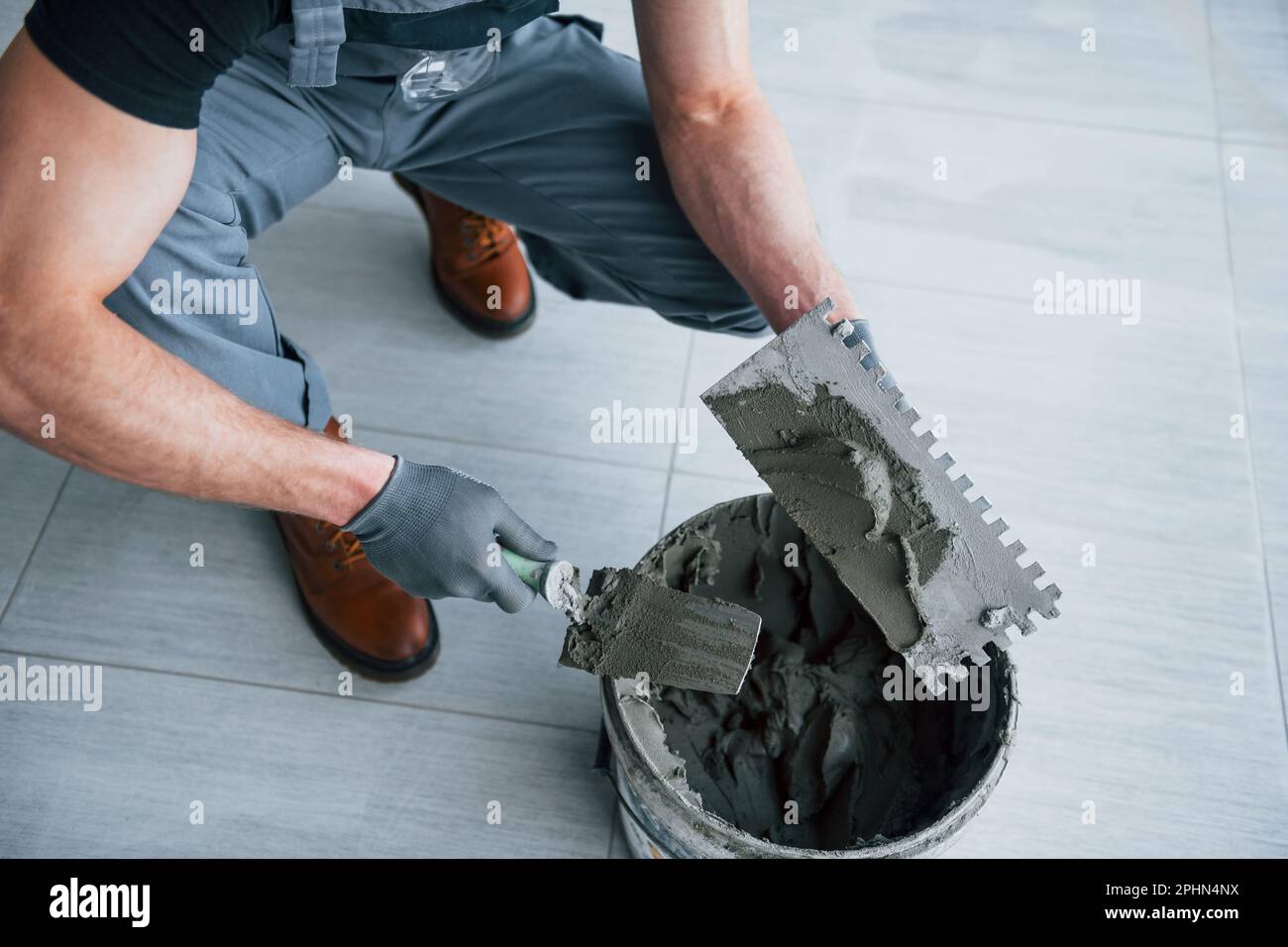 Man in grey uniform works with plate indoors in modern big office at ...