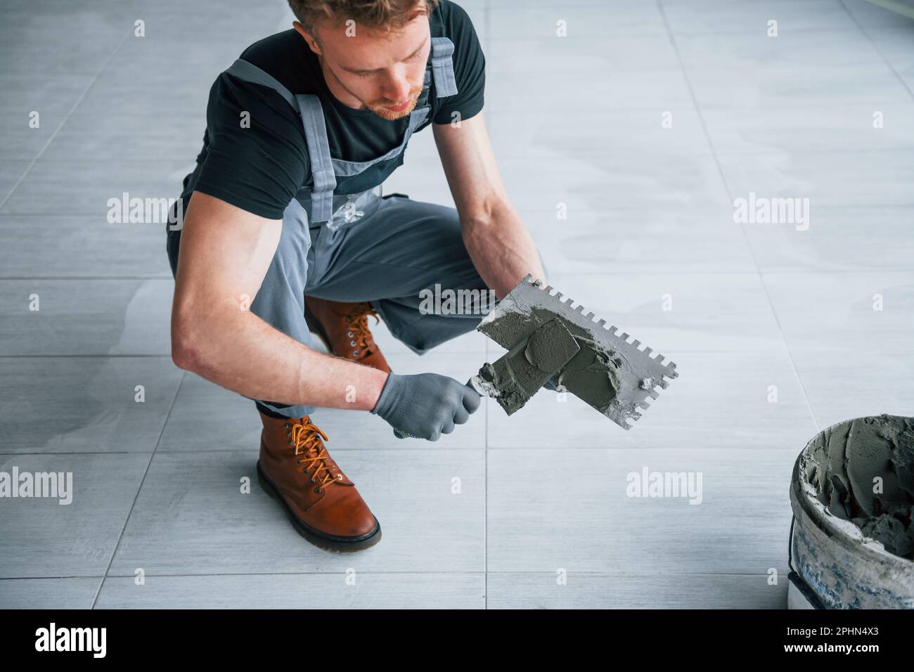 Man in grey uniform works with plate indoors in modern big office at ...