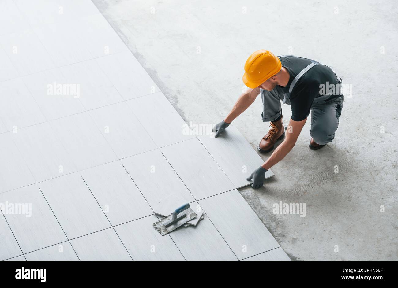 Installation of plates. Man in grey uniform and orange hard hat works ...
