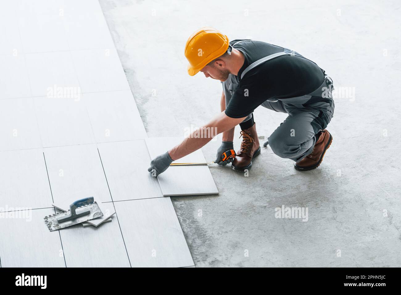 Installation of plates. Man in grey uniform and orange hard hat works ...