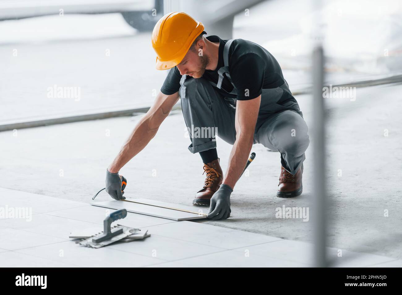 Installation of plates. Man in grey uniform and orange hard hat works ...
