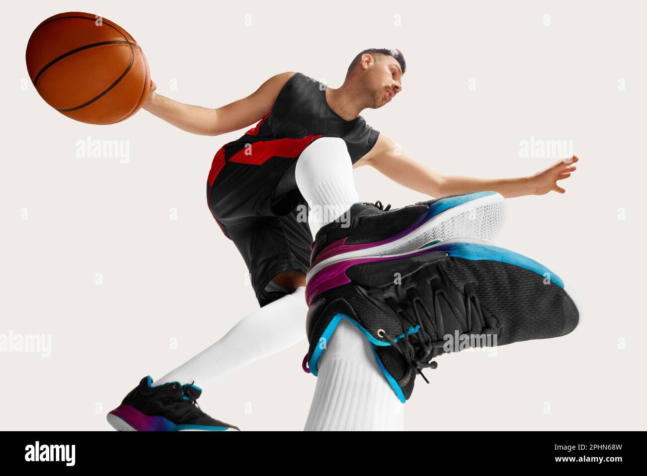 Portrait of athletic male basketball player training over white ...