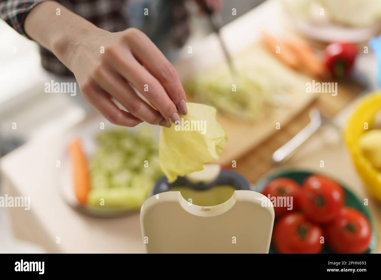 Cook throwing food peels in a compost bin with bokashi bran. Female ...