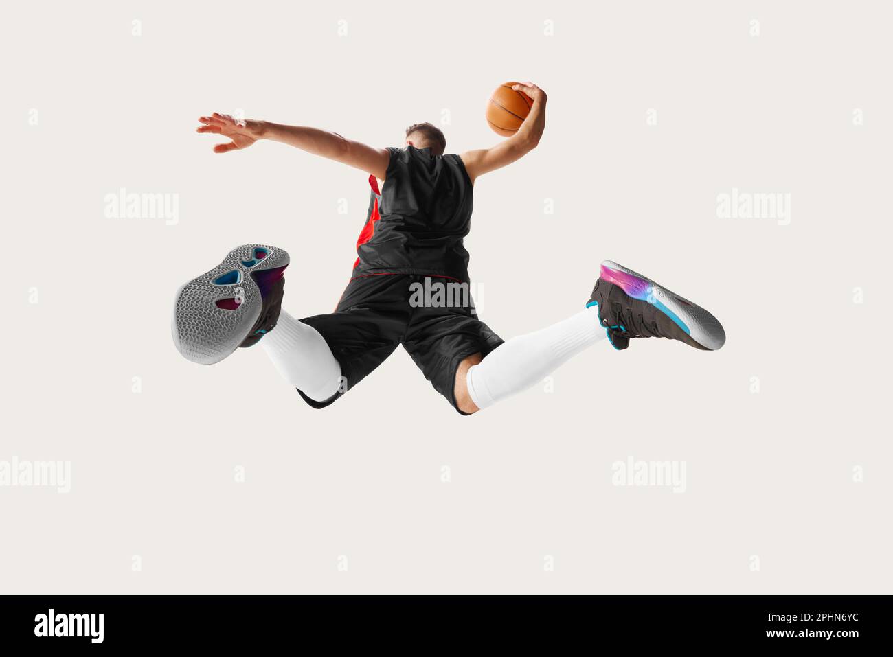 Portrait of male professional basketball player jumping and throwing ...