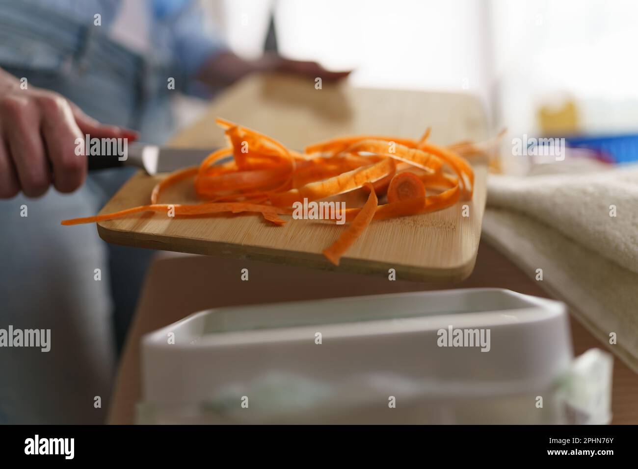 The cook throwing food peels in a compost container. Female person ...