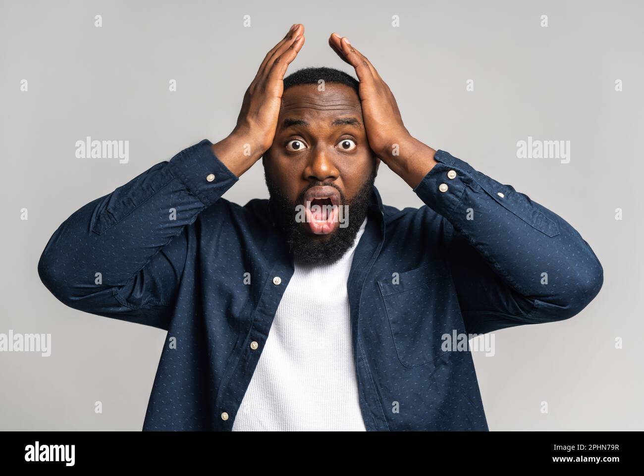 Shocked and terrified African-American guy looks at camera and ...