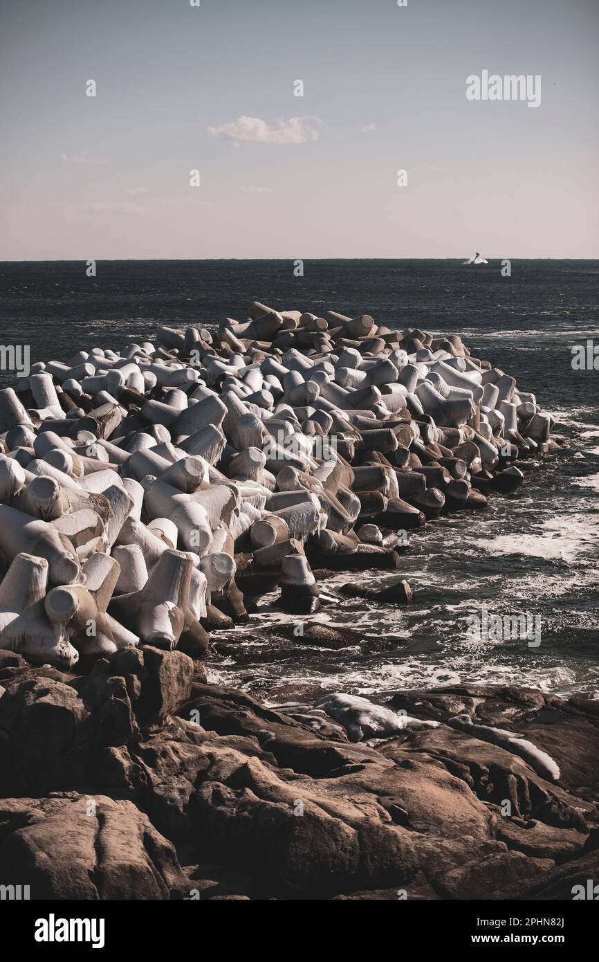 A scenic view of a rugged coastline with a line of small waves rolling ...