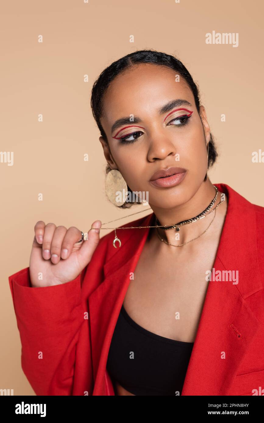 portrait of stylish african american model in bright red blazer pulling ...
