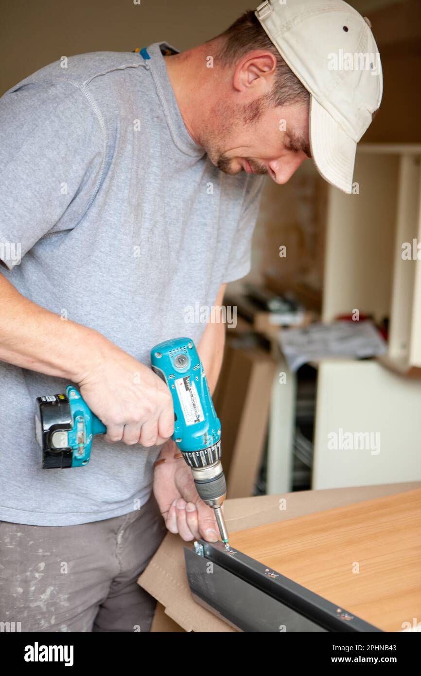 Kitchen Fitters: Making Drawers. A carpenter adding drawer fixtures to ...