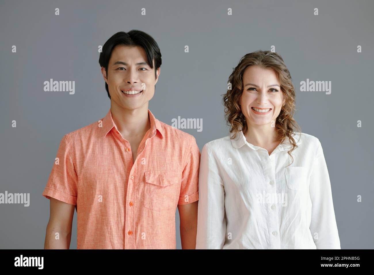 Happy couple with age difference posing against grey background Stock ...