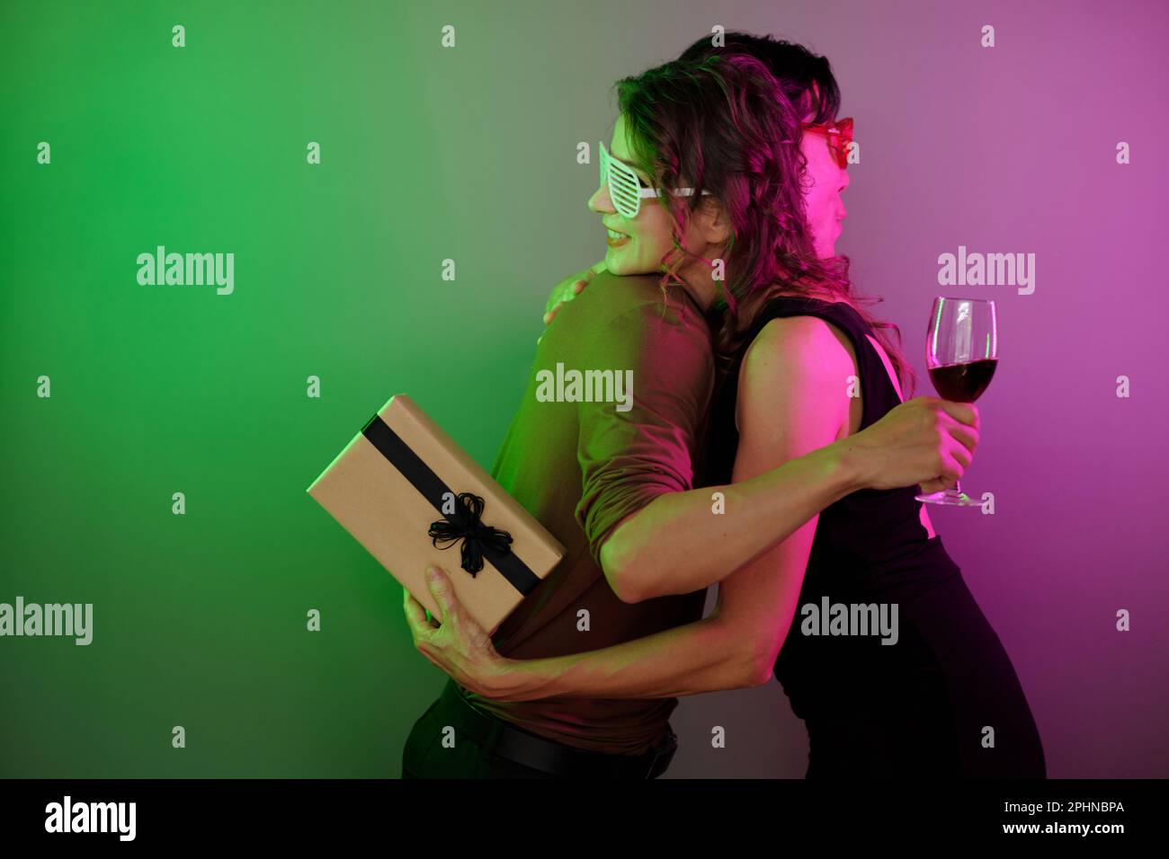 Happy woman hugging birthday party guest after receiving present Stock ...