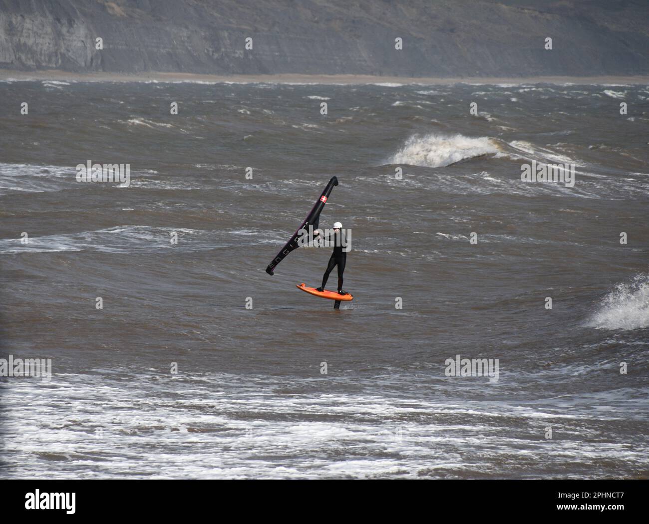 A Wing foil surfer skims through a choppy sea powered by a stiff breeze ...