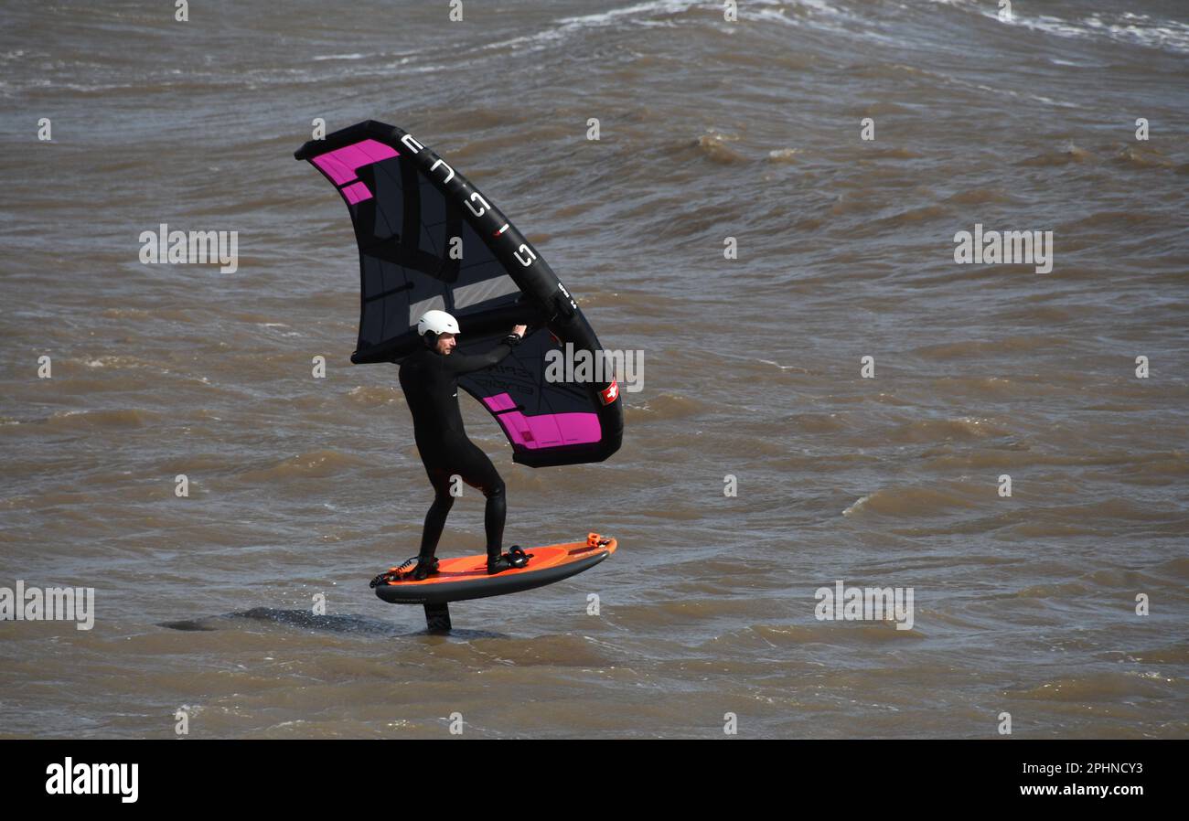 A Wing foil surfer skims through a choppy sea powered by a stiff breeze ...