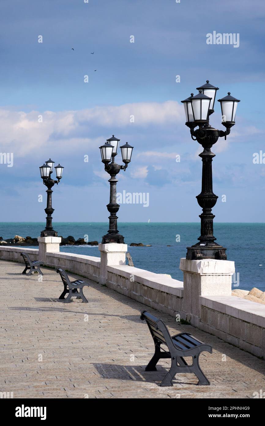 Wooden benches overlooking the serene waterfront promenade Stock Photo ...