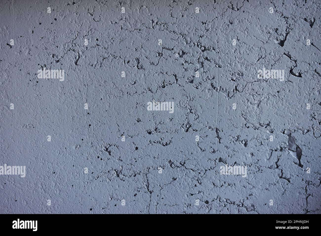 Background of grey wall with modern design of cracks. Indoors at home ...